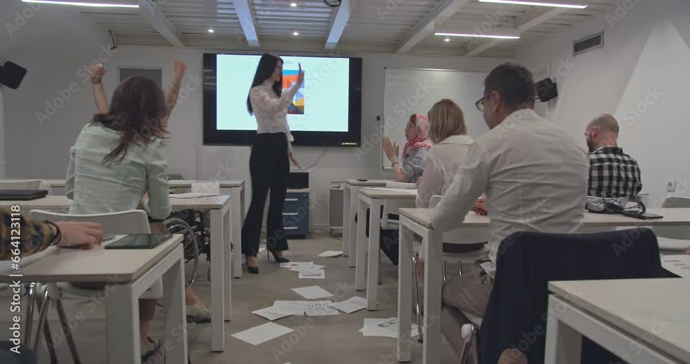 In the office classroom area, a beautiful female teacher is throwing ...