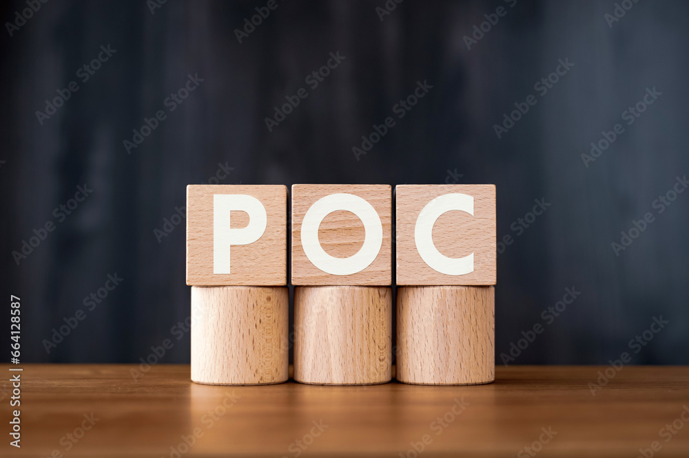 There is wood cube with the word POC. It is an abbreviation for Proof ...