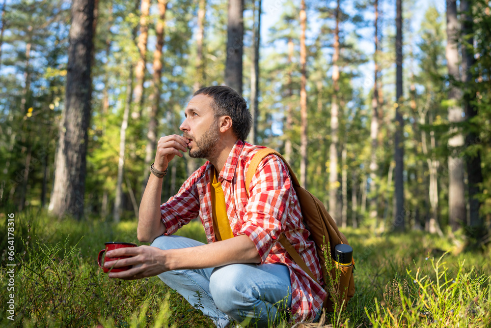 Foto de Man hiker backpacker drinking tea eating snack sitting in ...