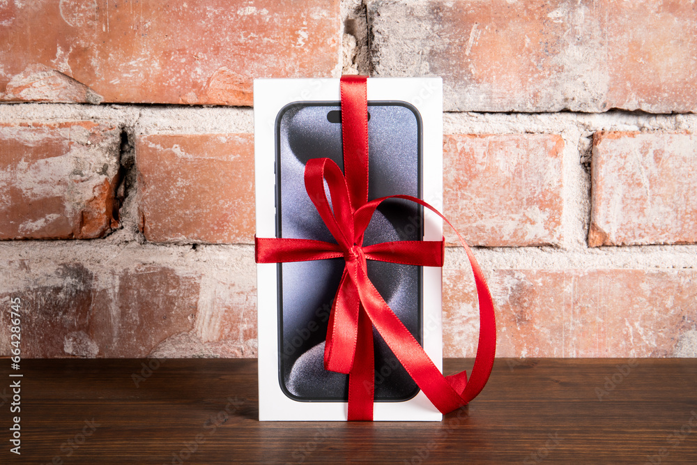Box of the Iphone 15 Pro on a red brick background. Gift with a red ...
