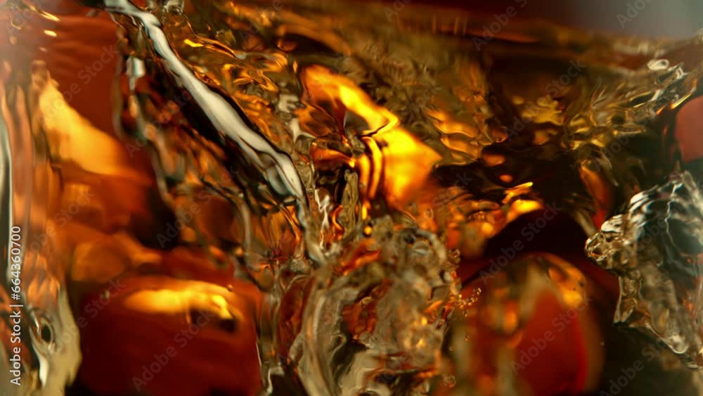 Super slow motion of falling ice cube into whiskey drink. Filmed on ...