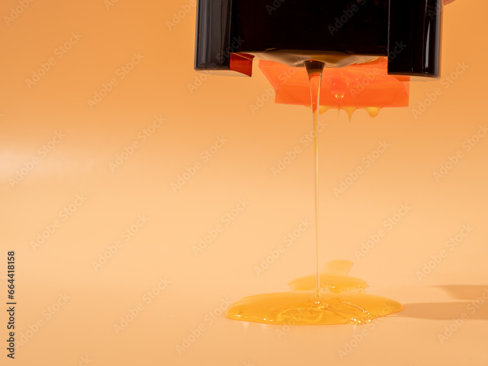 Liquid shower gel flows gracefully across a bright orange background ...