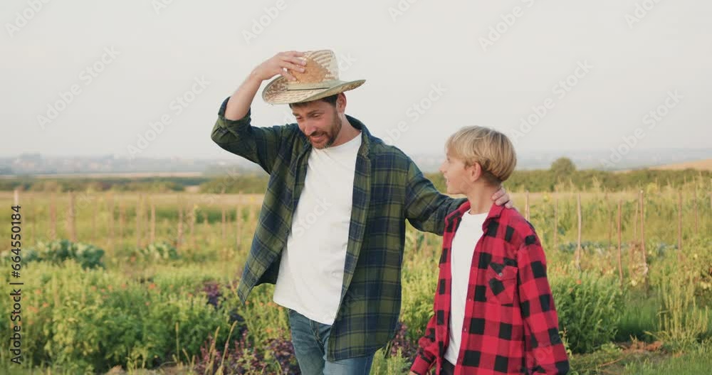 Farmer father son walking together in vegetables field. Man farmer ...