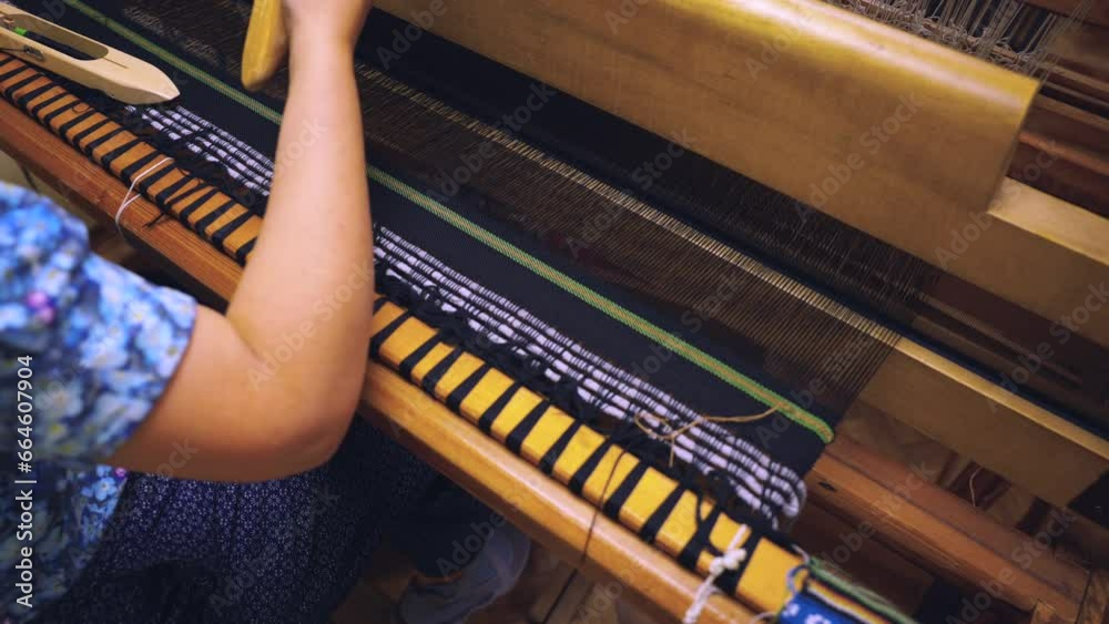 Woman is warping a wooden handloom. Hands holding a heddle hook and ...