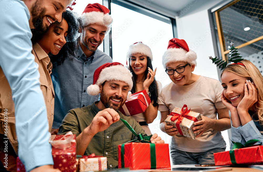 Secret Santa. A smiling man unpacks a Christmas present from colleagues ...
