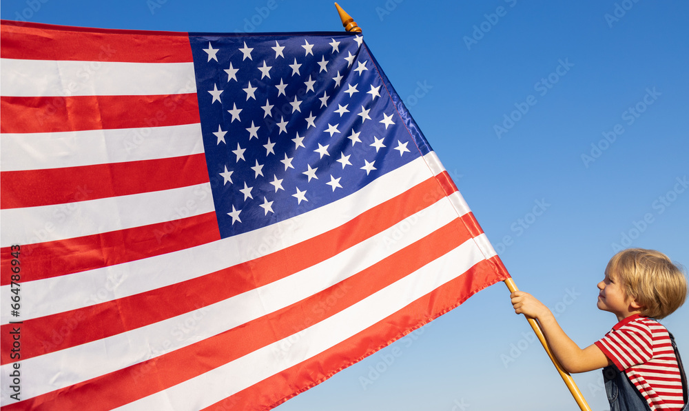 child proudly holds a large American flag against a background of blue ...