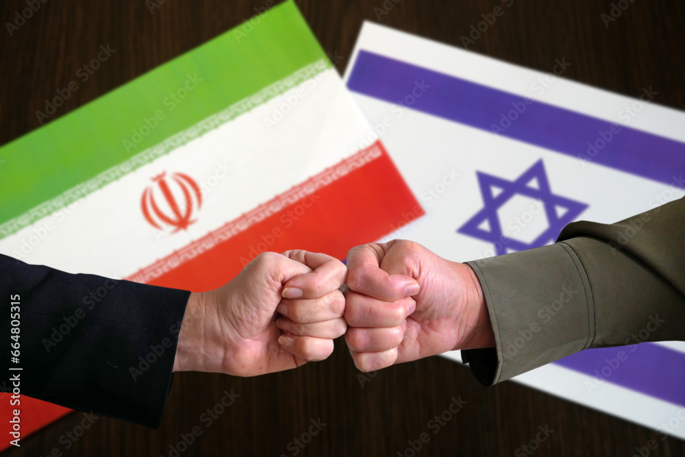 hands clenched into fists against the background of the flags of Israel ...