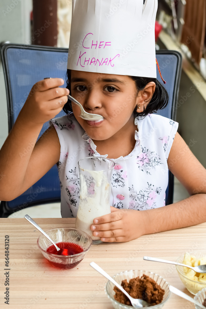 Cute Indian chef girl preparing sundae dish as a part of non fire ...