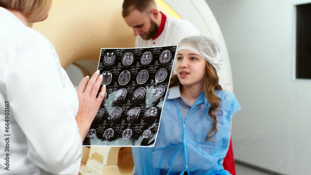In a modern clinic, a female radiologist explains the good results of a ...