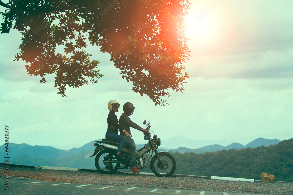 couples wearing safety helmet sitting on small enduro motorcycle ...