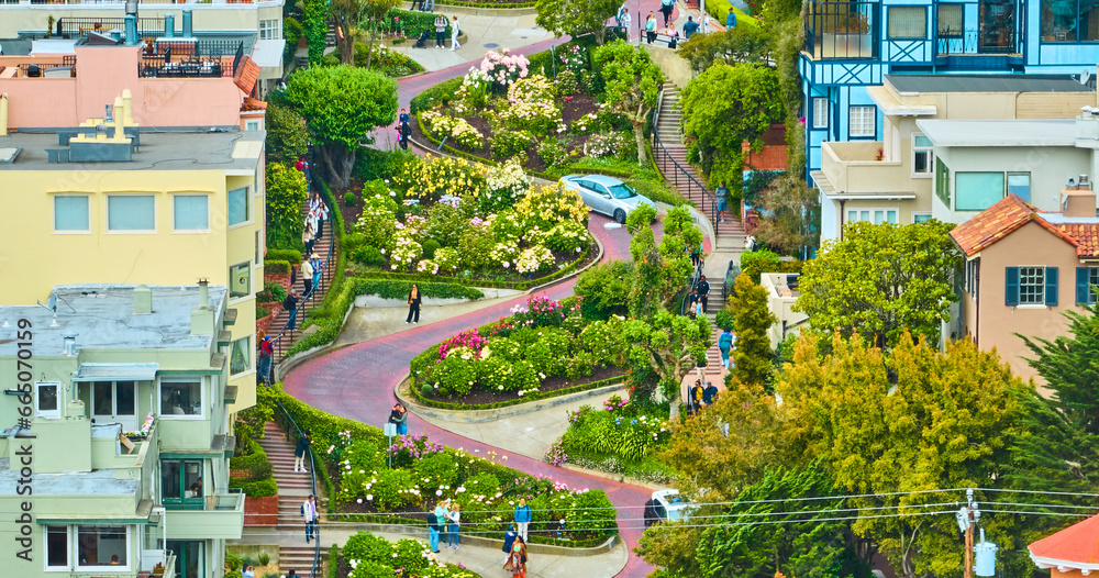 Zoomed in aerial of people navigating Lombard Street with silver car ...