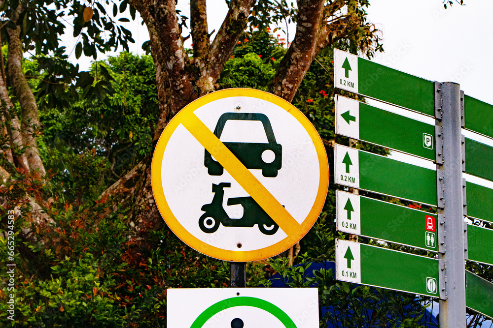 Signs prohibit motorcycle and cars pass located on side of road, green ...