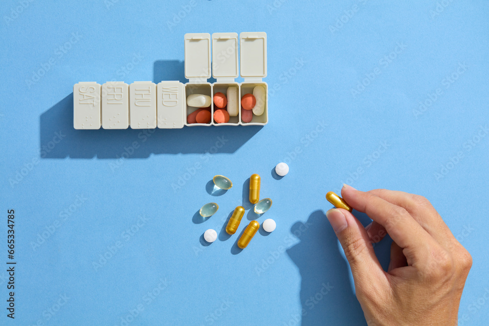 Flat lay of drug container with pills of various colors and shapes ...