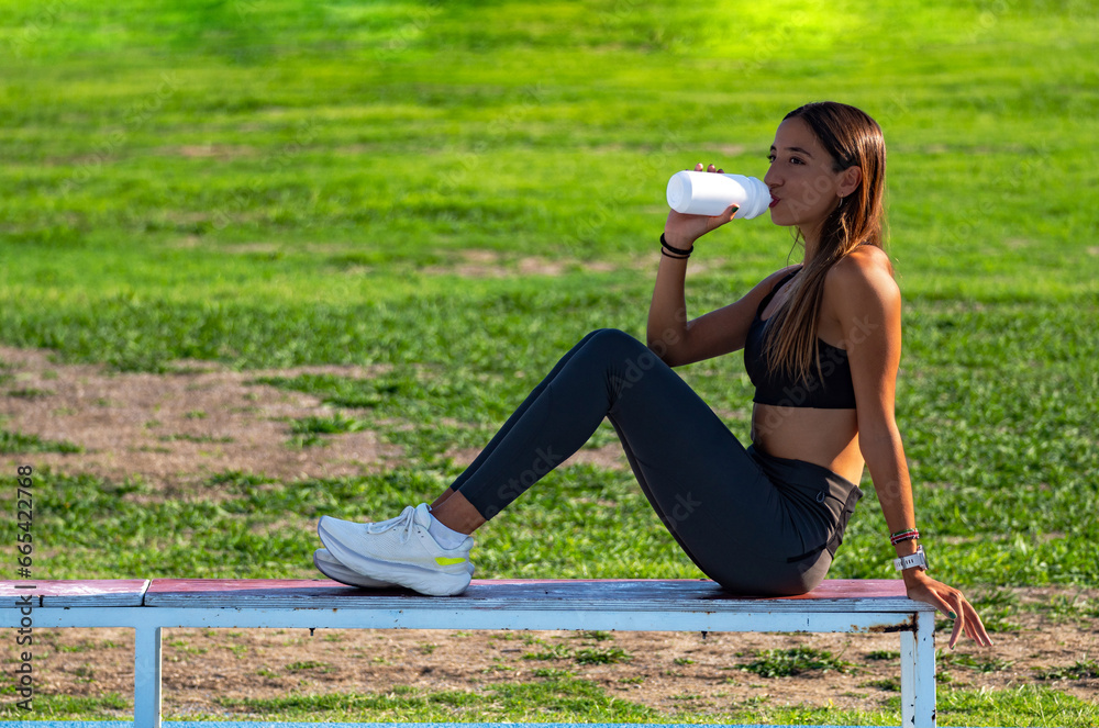 Beautiful young runner girl, tanned with long hair and dressed in tight ...