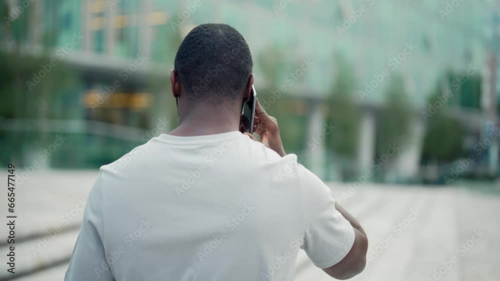 African american guy talking on phone standing on street back to camera ...