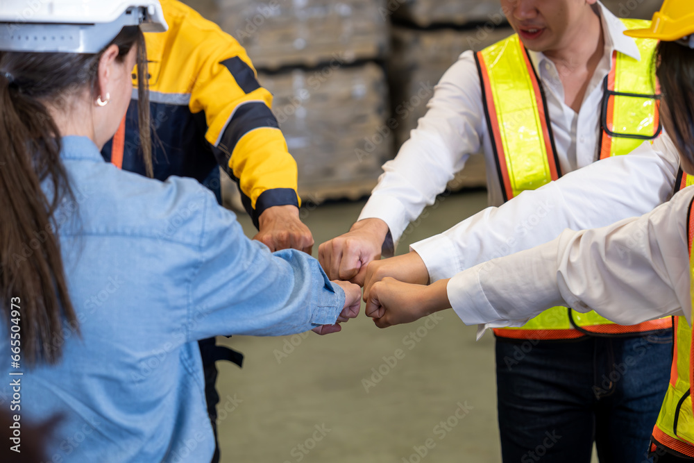 Cohesive and united group of factory worker joining hands together in ...