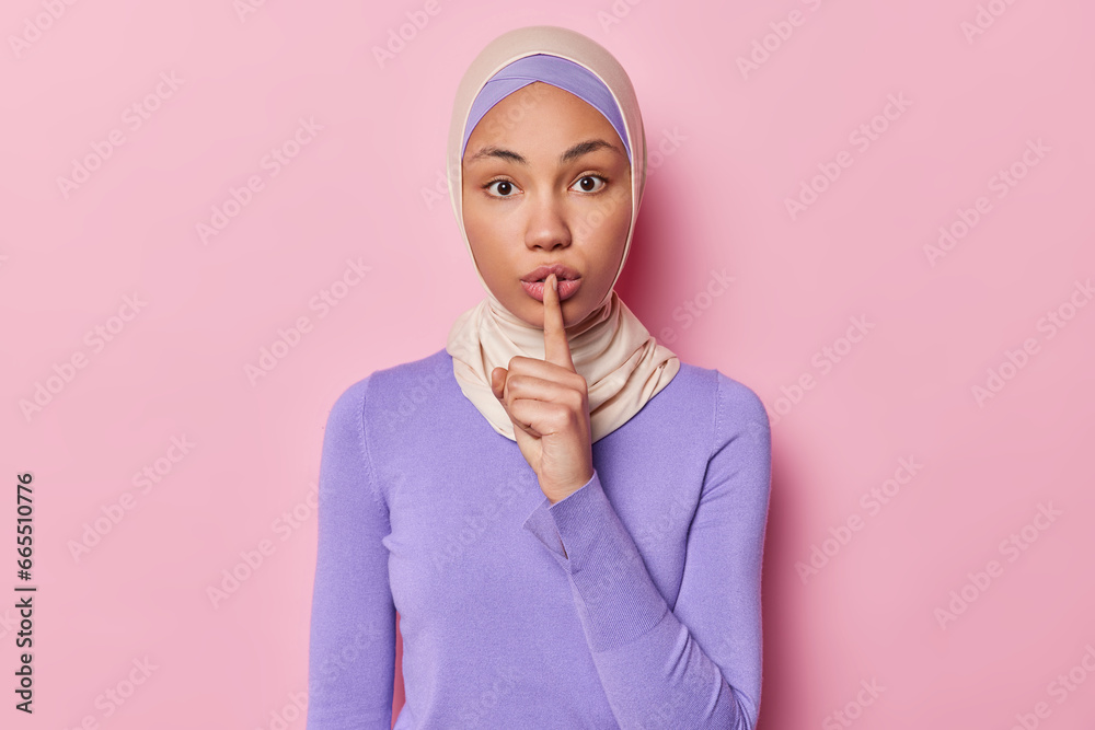 Mysterious Muslim woman keeps index finger over lips makes silent ...