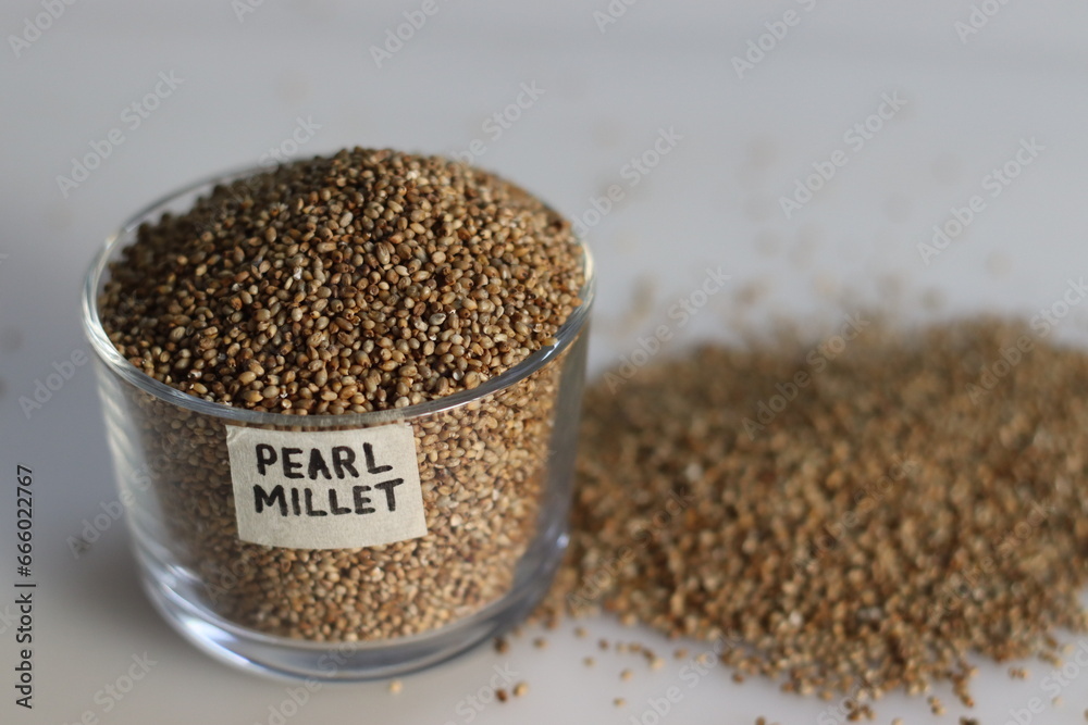 Pearl millet grains in a glass bowl with label on it filled to the brim ...