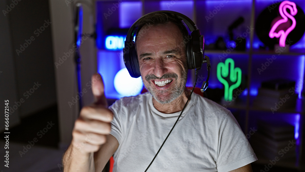 Smiling middle age man, grey hair streamer with beard, rocking thumb up ...