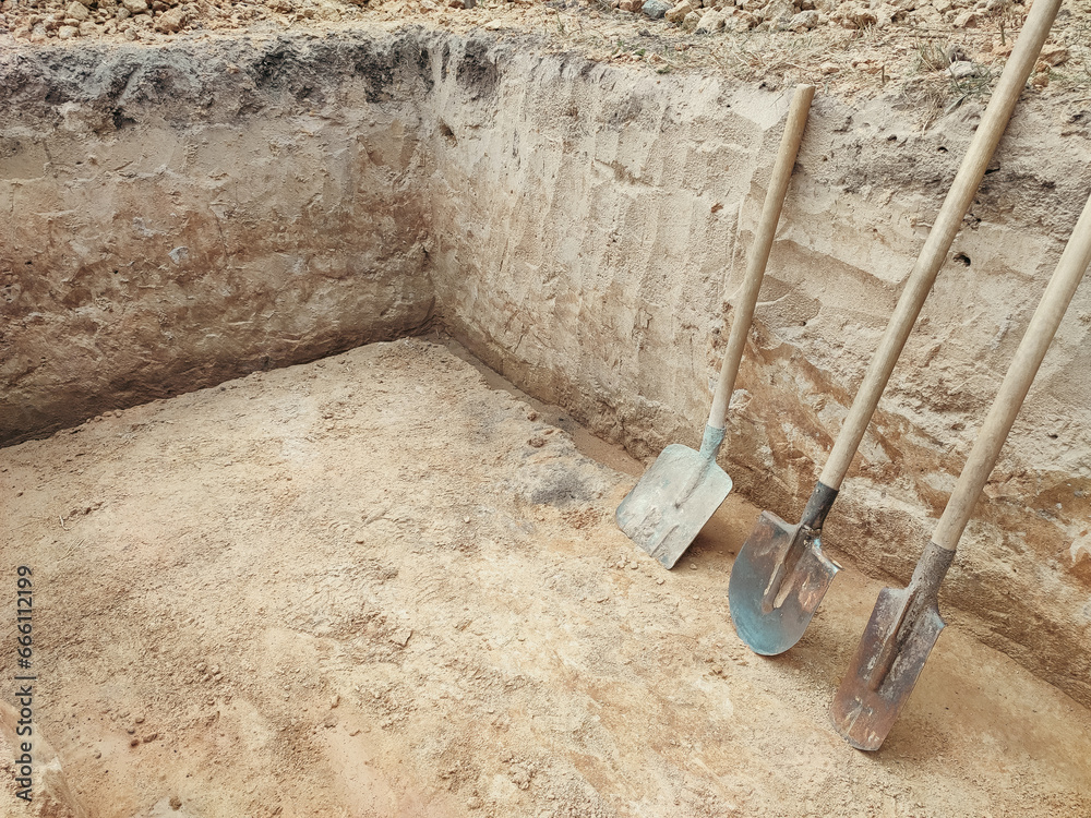 Pit in the ground. Digging a pit. The shovels in the pit. Earthworks ...