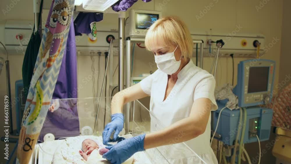 Female nurse doctor taking care of newborn baby inside incubator. Woman ...