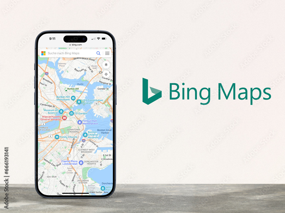 modern smartphone displaying map view of Bing Maps, standing on a stone desk in front of a gray ...