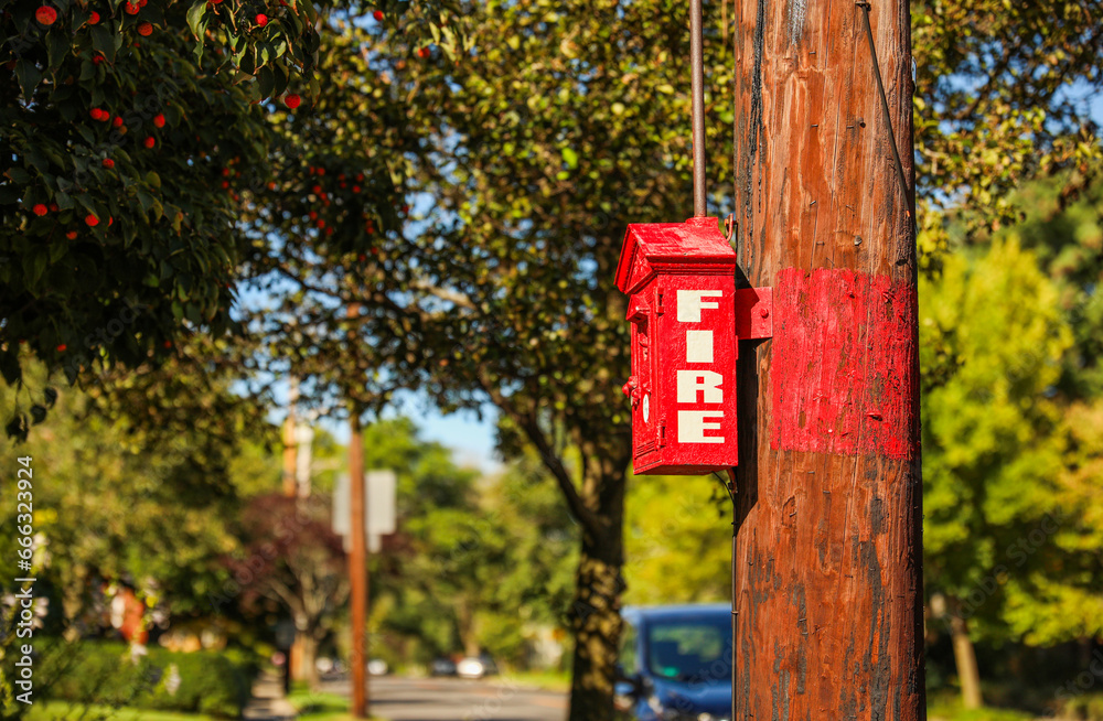 red, wall-mounted fire alarm with a glowing indicator, ready to alert ...