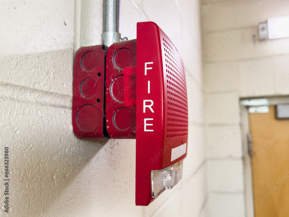 red, wall-mounted fire alarm with a glowing indicator, ready to alert ...
