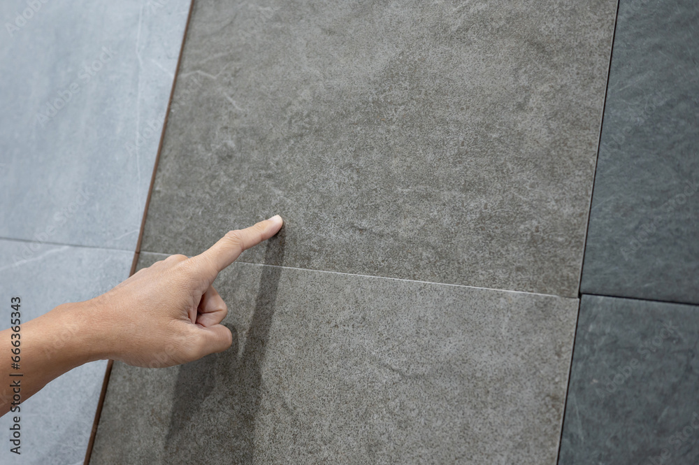 Male hand pointing at stone tile texture choosing sample material for ...