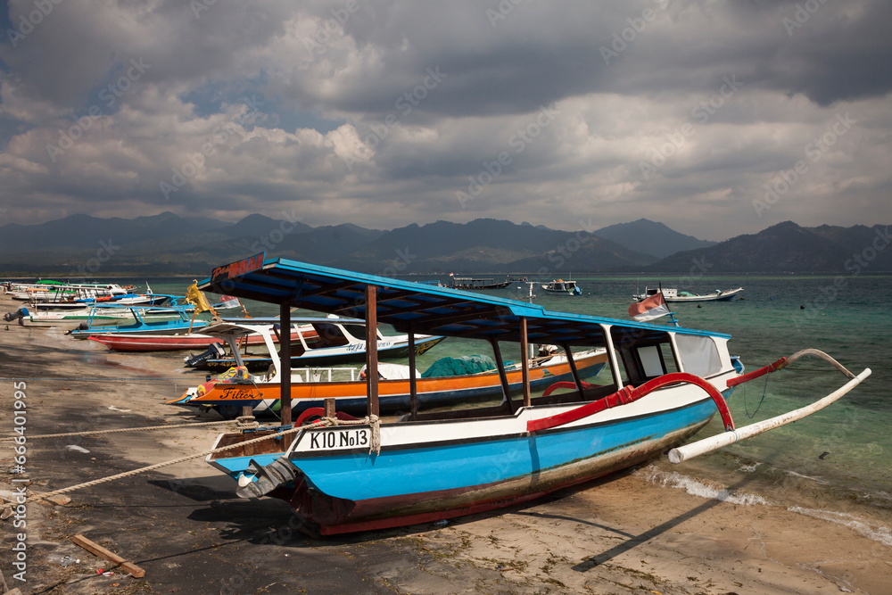 Row of traditional Indonesian fishing and public ferry boats aground on ...