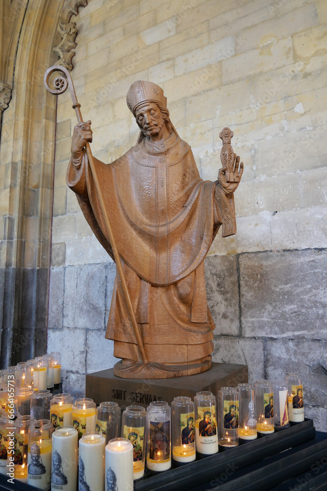 Statue of the Saint Servatius of Tongeren surrounded by prayer candles ...