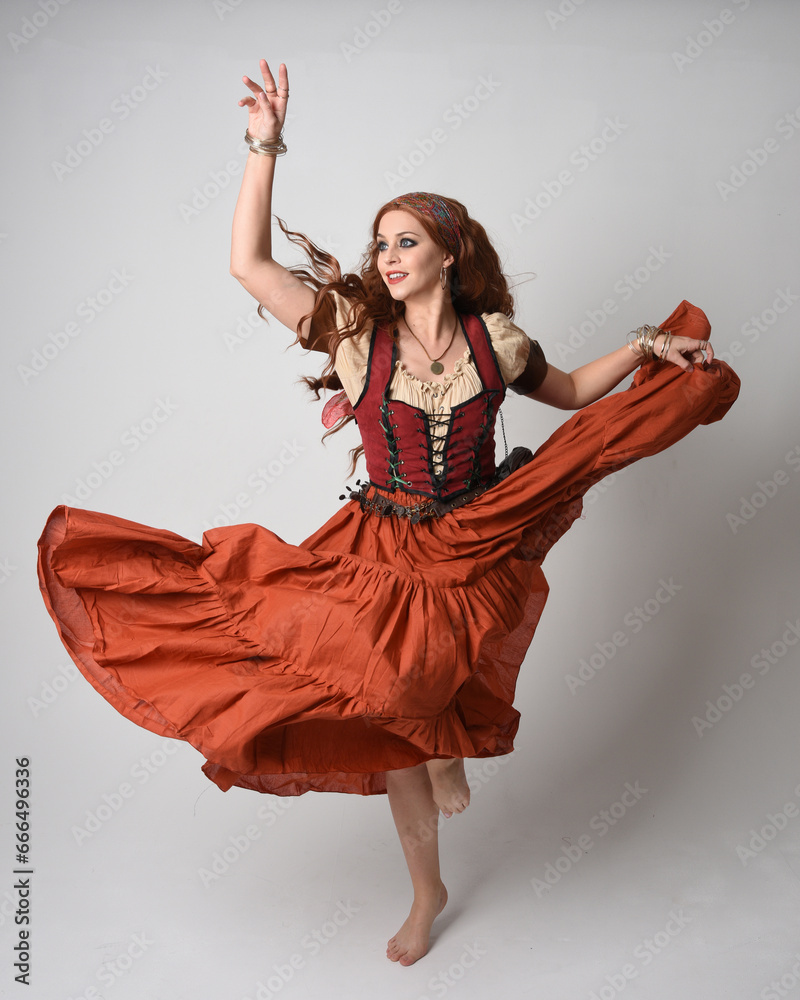Full length portrait of beautiful red haired woman wearing a medieval ...