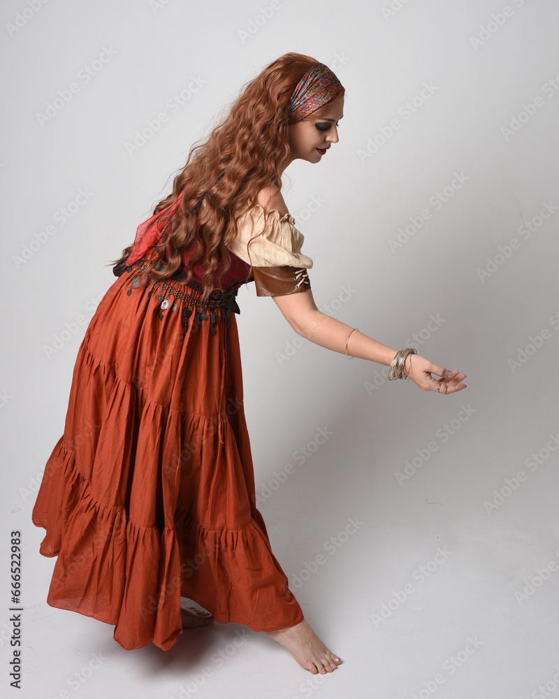 Full length portrait of beautiful red haired woman wearing a medieval ...