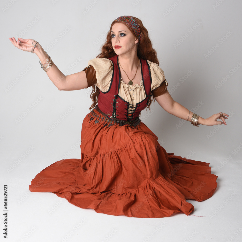 Full length portrait of beautiful red haired woman wearing a medieval ...
