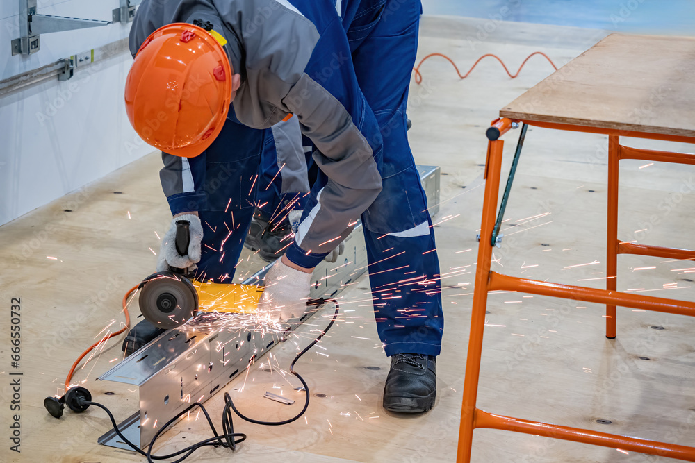 Man is sawing metal profile. Worker uses circular saw. Foreman cuts ...