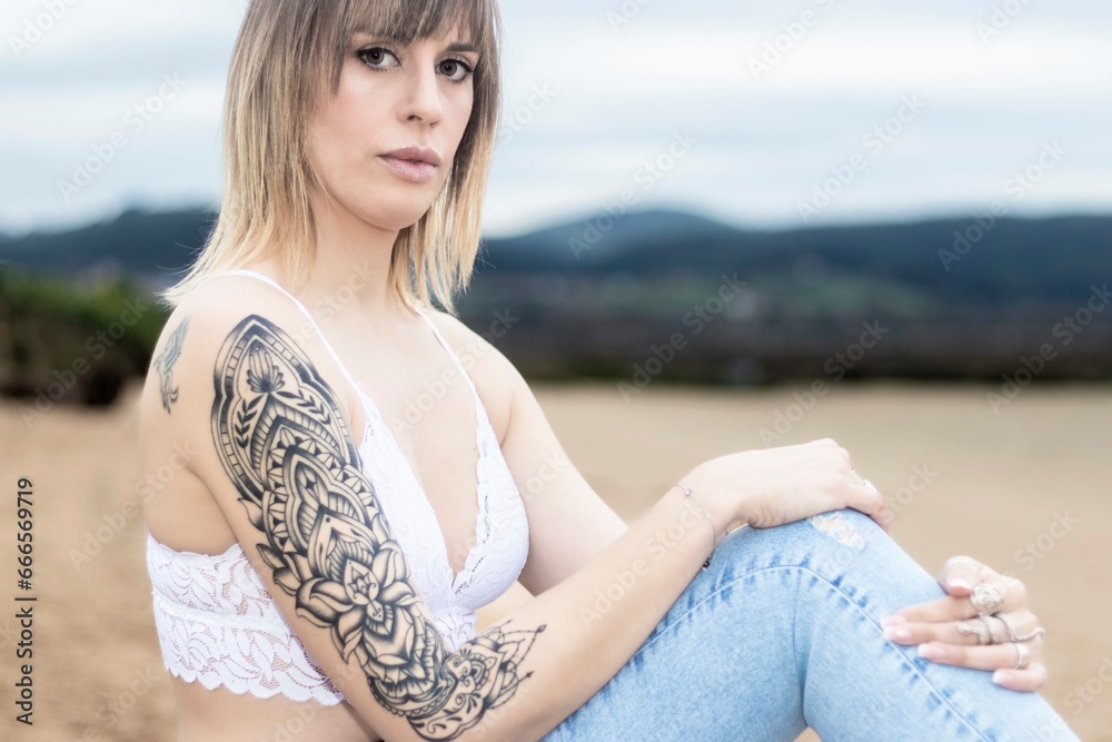 Inked and Inspired: A Blonde Tourist with a Shoulder Tattoo Embraces the Beach Life Stock Photo ...