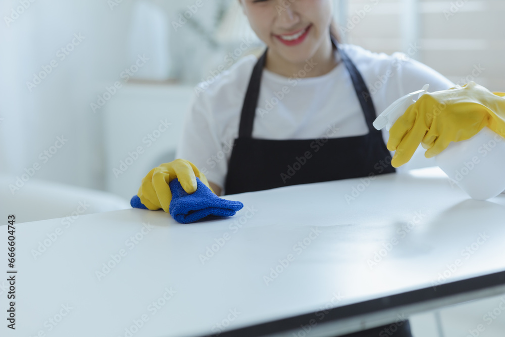 Asian female cleaner wiping down tables with cleaning spray, Wear ...