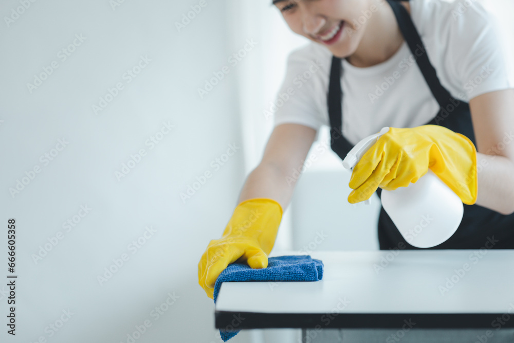 Asian female cleaner wiping down tables with cleaning spray, Wear ...