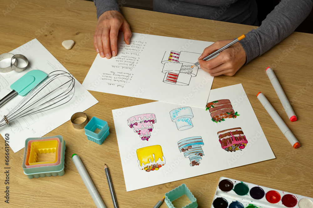 The pastry chef develops a cake design by drawing on paper. Creation of ...
