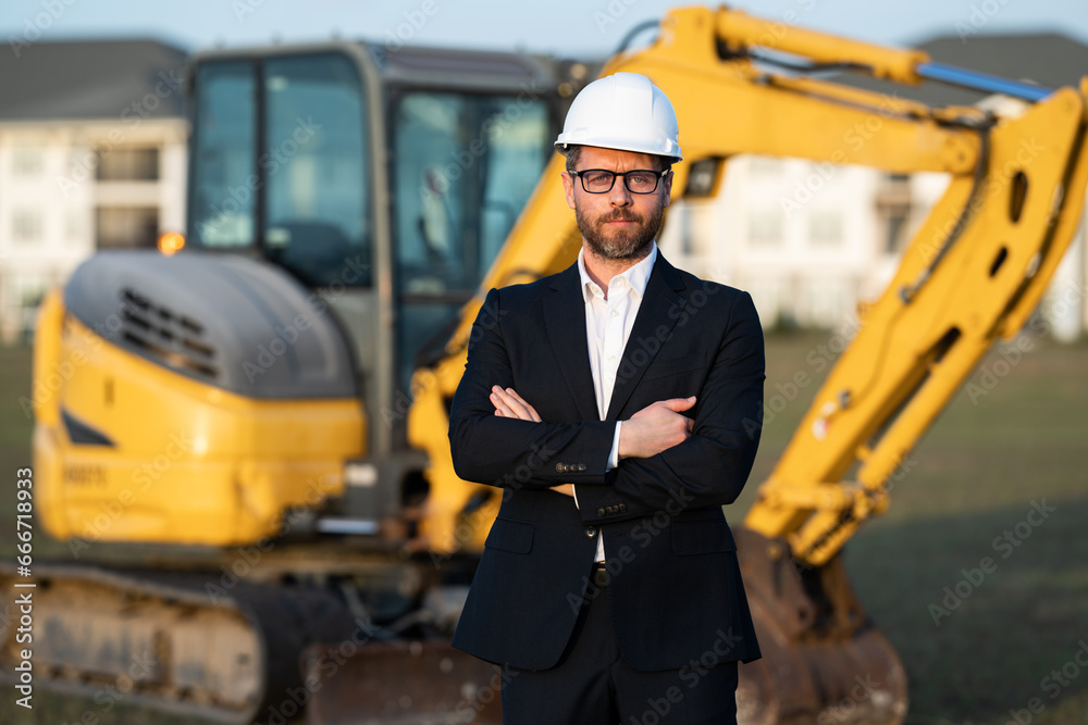 Construction owner near excavator. Confident construction owner in ...