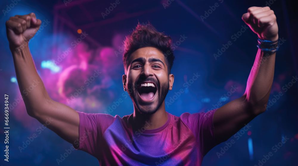 Happy Indian man in ultraviolet neon studio background champion coding achievement level up ...