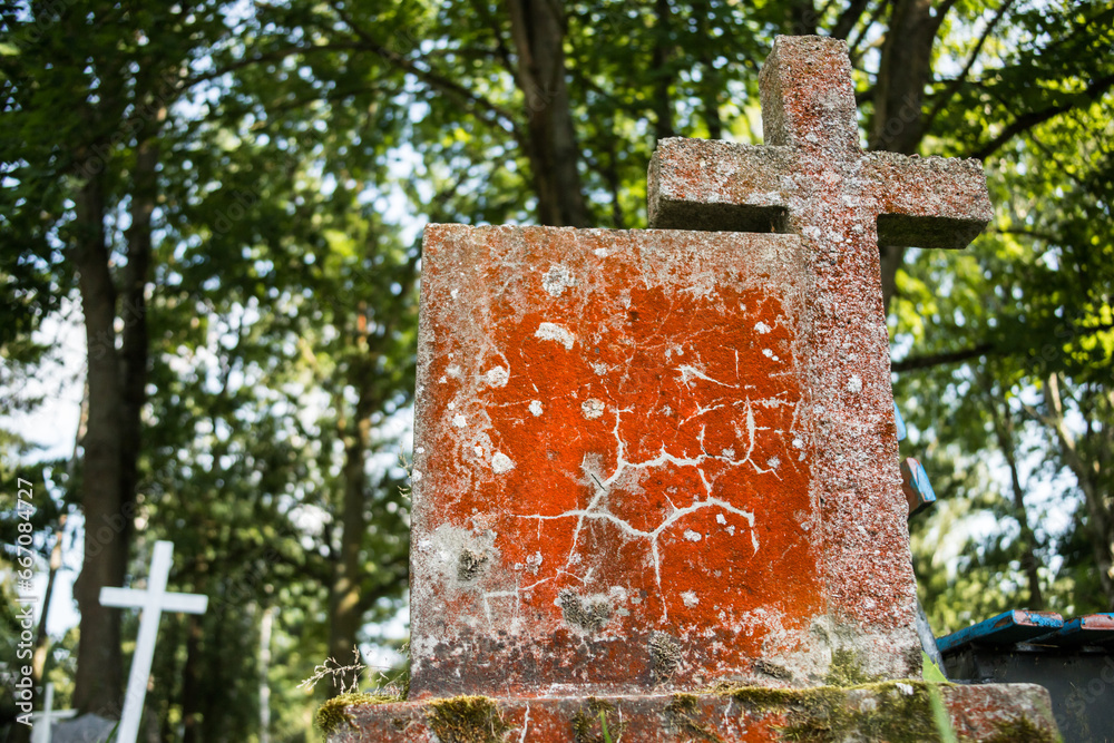 rusty coating of Trentepohlia algae on an old tombstone with a cross ...