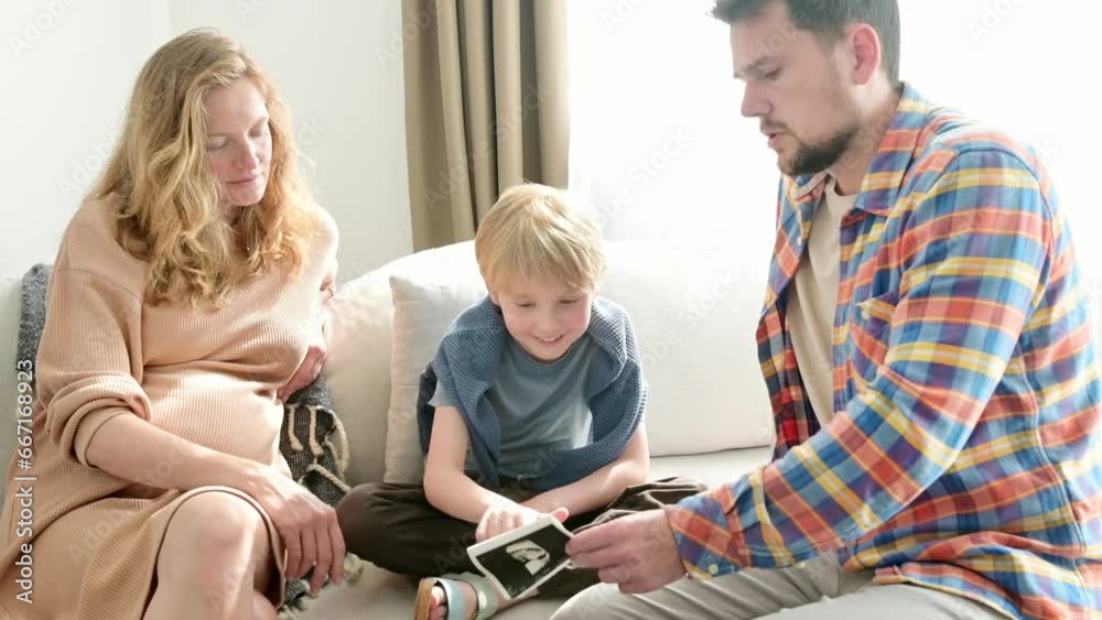 Parents show their son a photo of their future baby. A teenage boy will ...