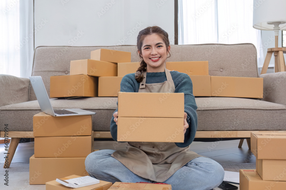 Young Asian woman starting a small business Freeman holding parcel box ...