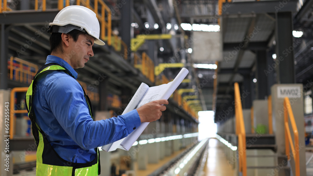 Young railway engineer hold blueprint drawing work at the sideline ...