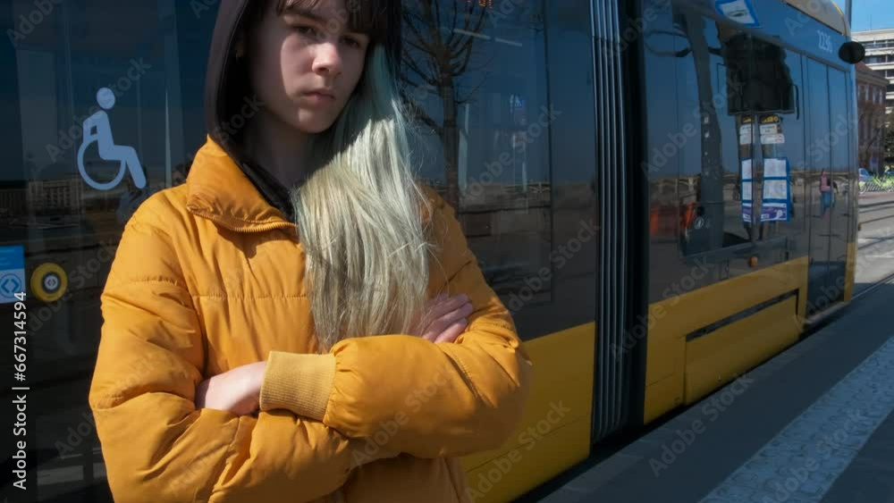 Sad emotional girl by tramway. A view of emotional teen girl with ...