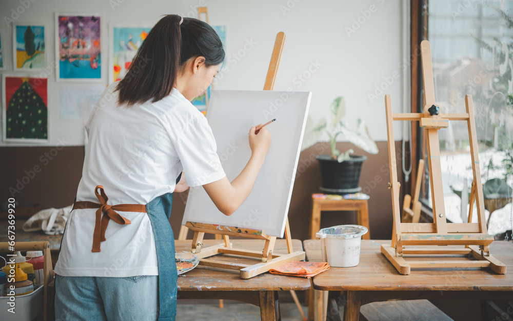 Poster Art student drawing with watercolor painting on canvas doing ...