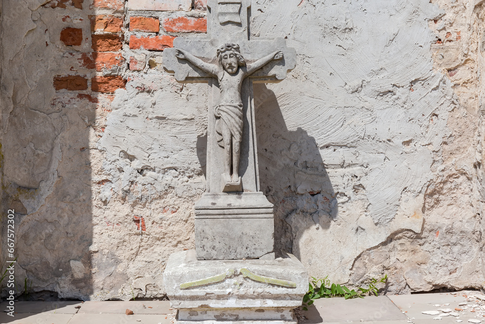 Ancient stone sculpture of crucified Jesus against the fortress wall ...