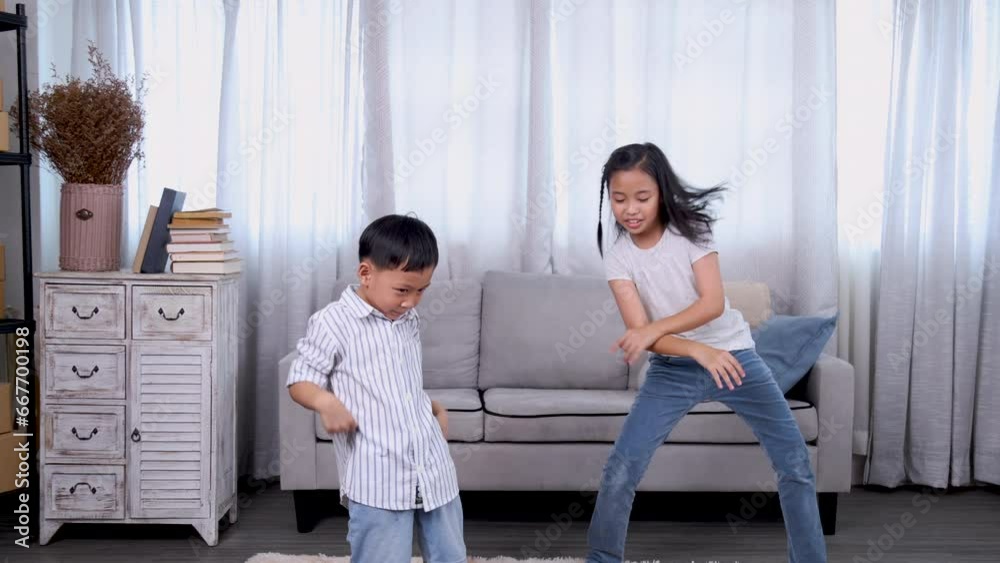 Cute sibling children overjoyed dancing together with cheerful laughing ...