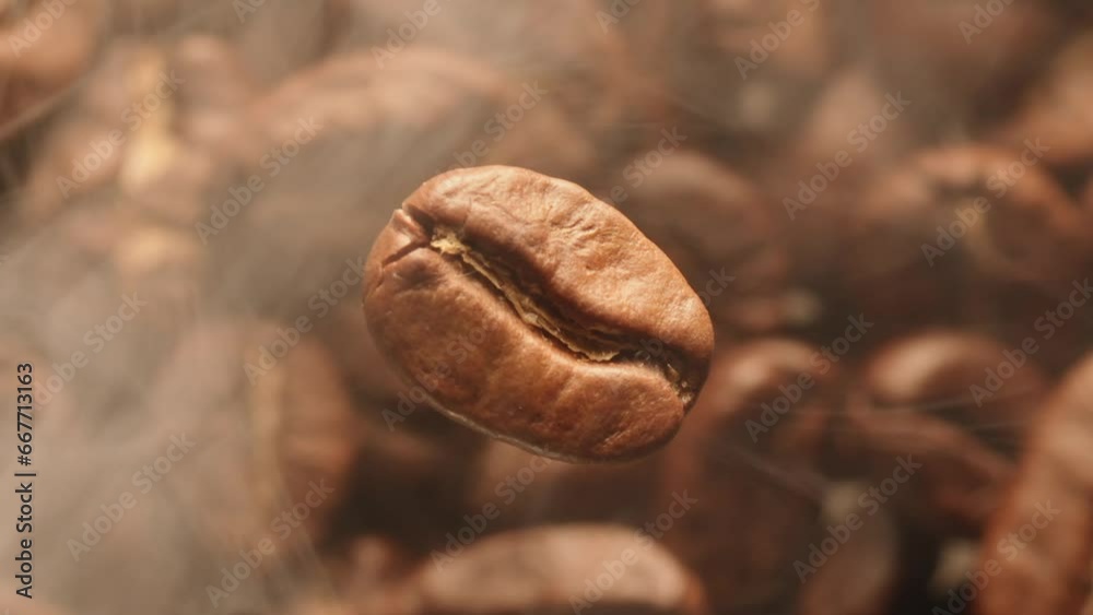 Macro slow motion video of a rotating coffee bean with an out of focus background of roasting ...